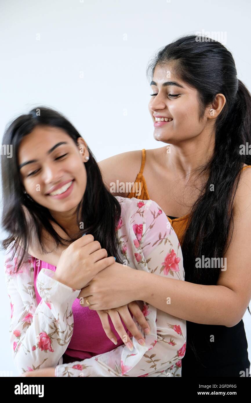 Vertical closeup of two girls hugging each other Stock Photo - Alamy