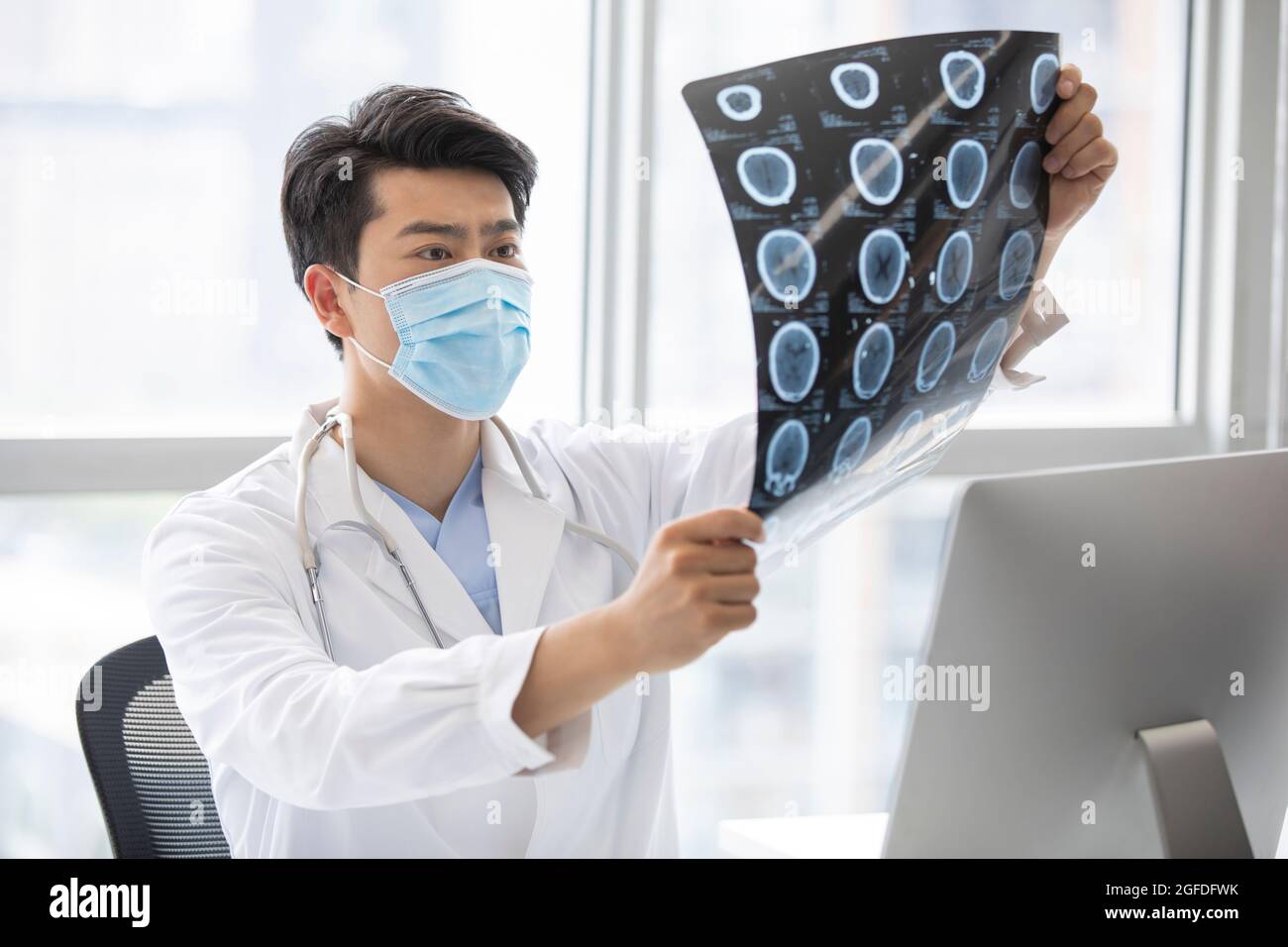 Young doctor checking X-ray image Stock Photo - Alamy