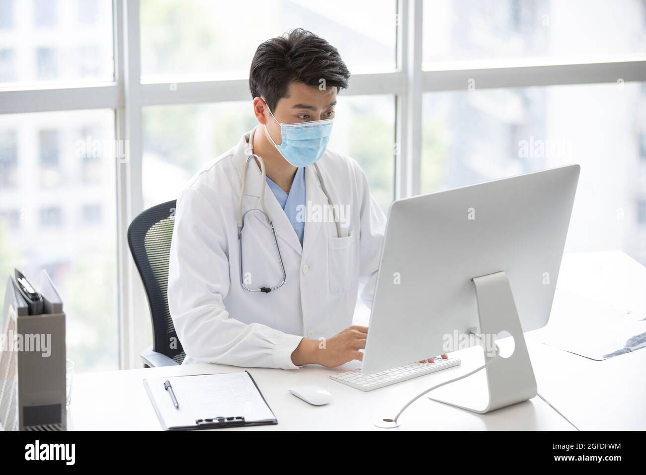 Young doctor using computer in doctor's office Stock Photo - Alamy