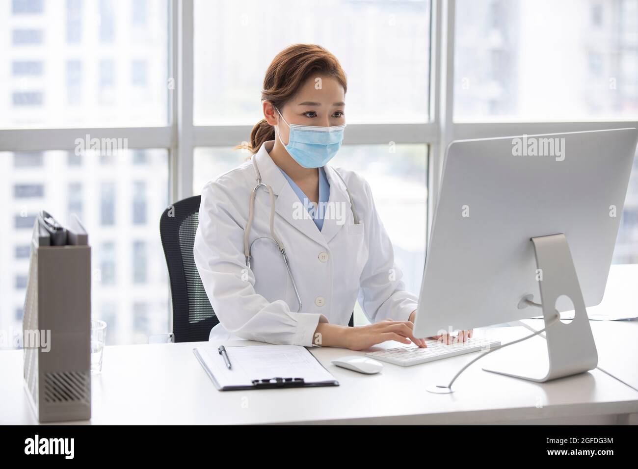 Young doctor using computer in doctor's office Stock Photo - Alamy