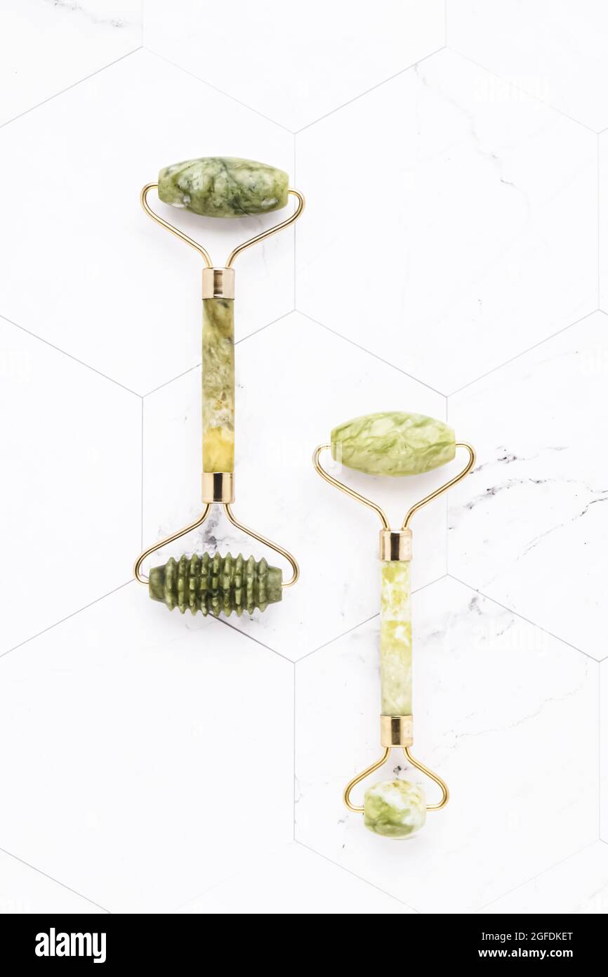 Green jade face rollers on a white marble background. SPA concept. Top ...