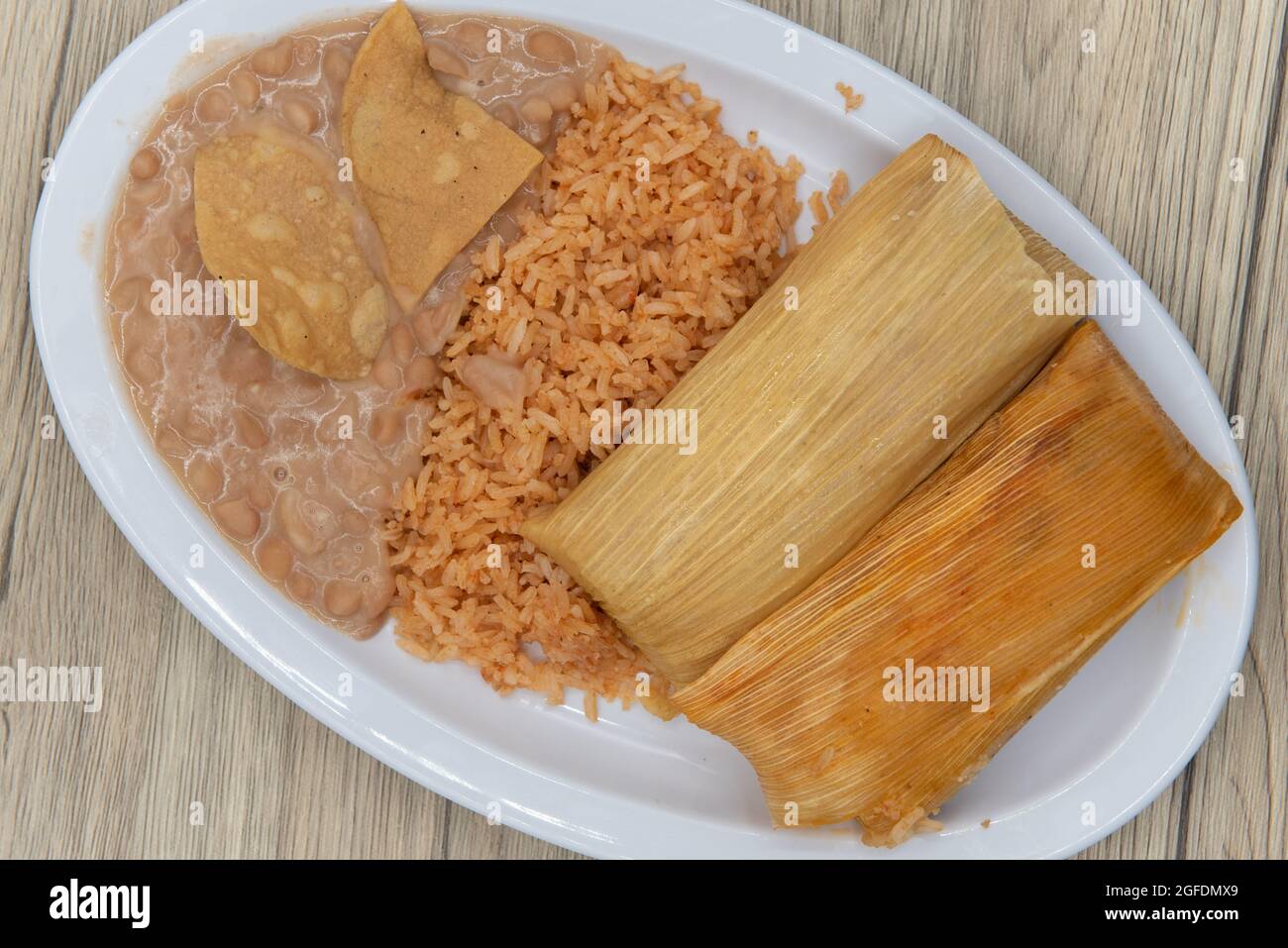 Overhead view of hearty plate of tamales wrapped in corn husk, served ...