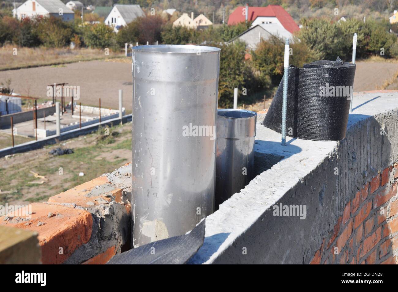 The construction of a brick chimney with two flues, steel pipes ...