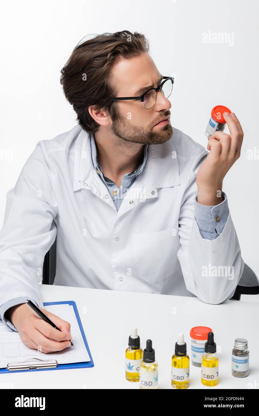 doctor writing prescription while holding medical cannabis medication ...