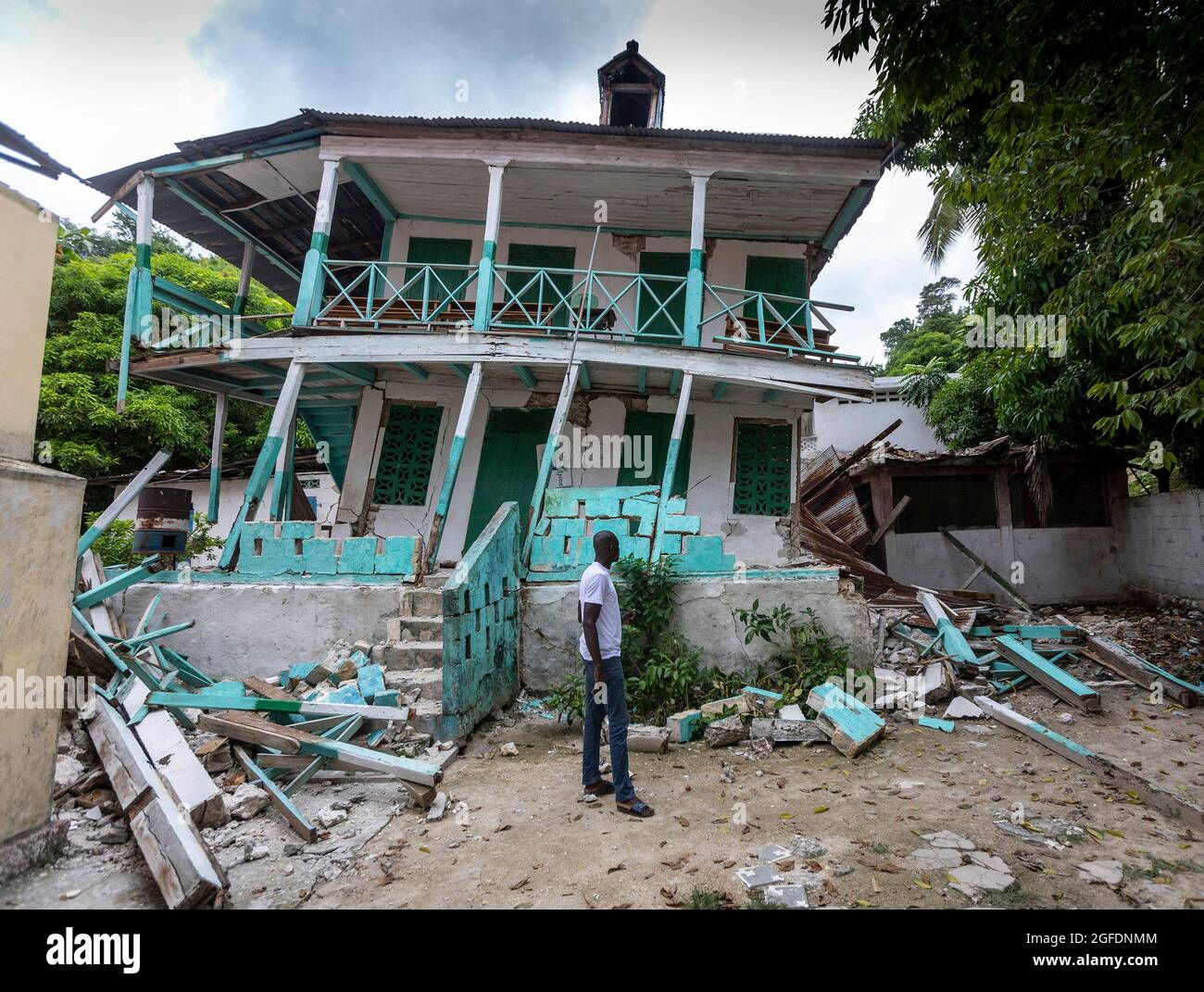 A man stands in front of a damaged school in Corail, Haiti, on August ...