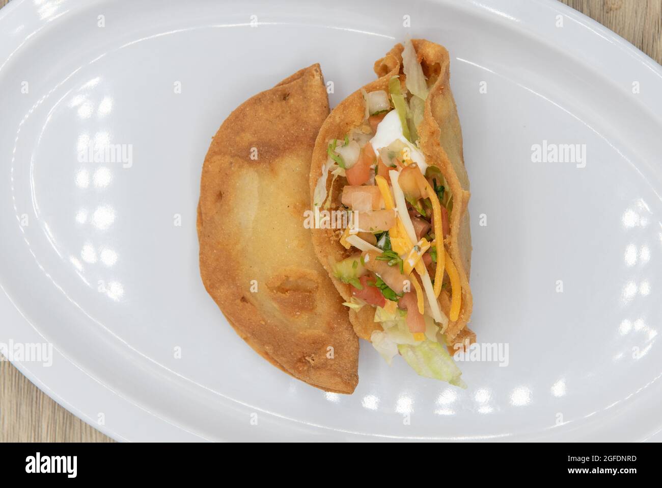 Overhead view of hearty side order of crispy fried potato taco loaded ...