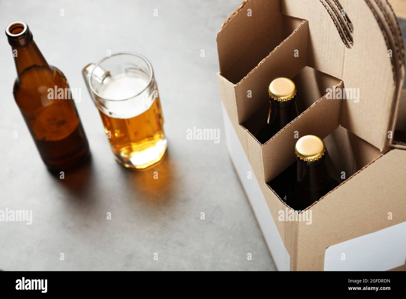 Paper beer package with mug on grey background Stock Photo - Alamy