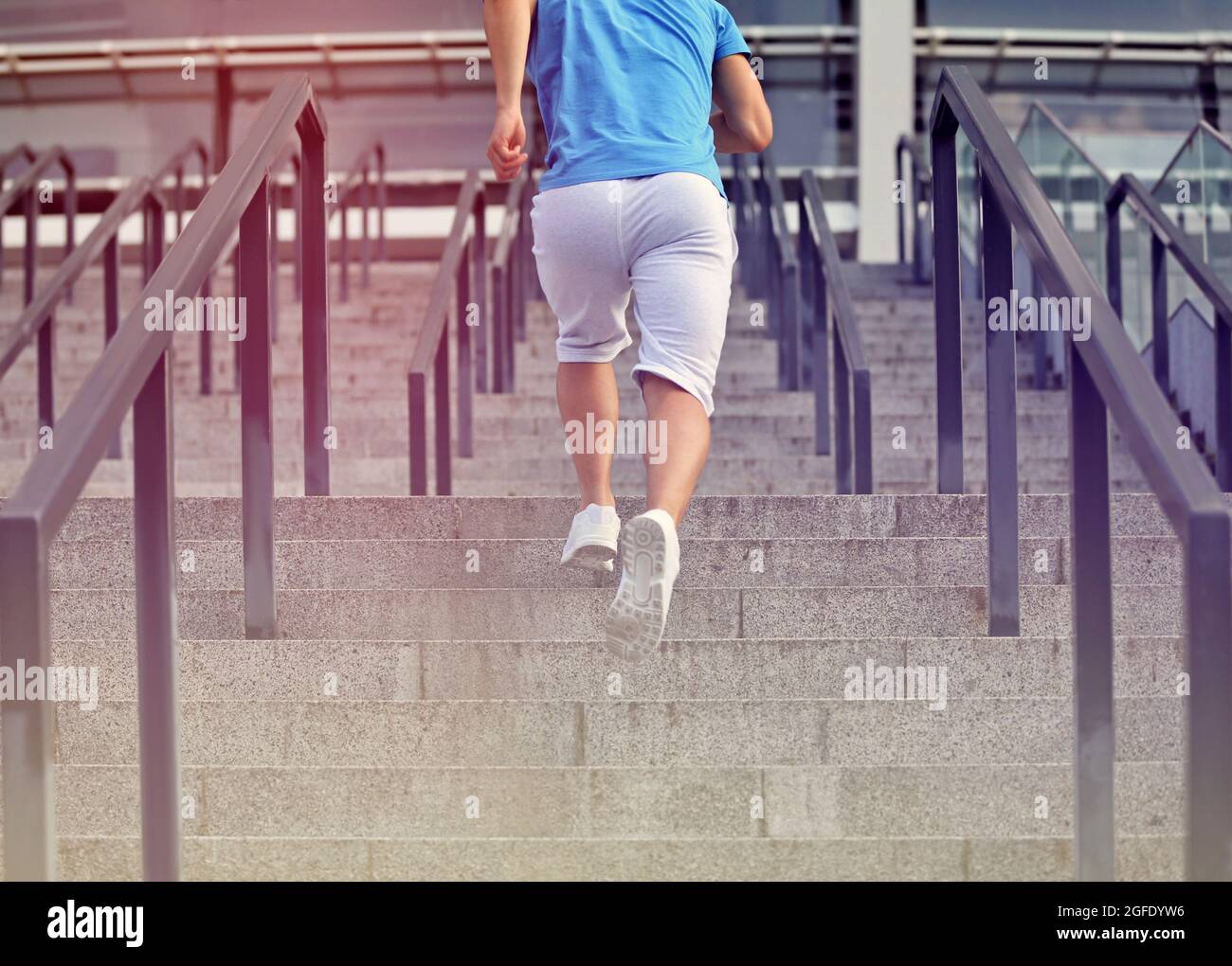 Young man running on stairs Stock Photo - Alamy