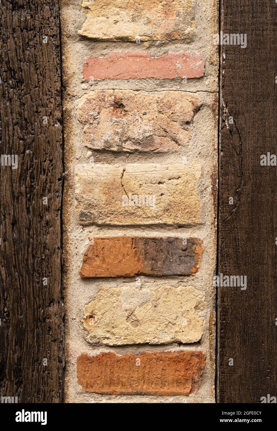 Close up of combined old wooden and brick wall of colorful bricks in ...