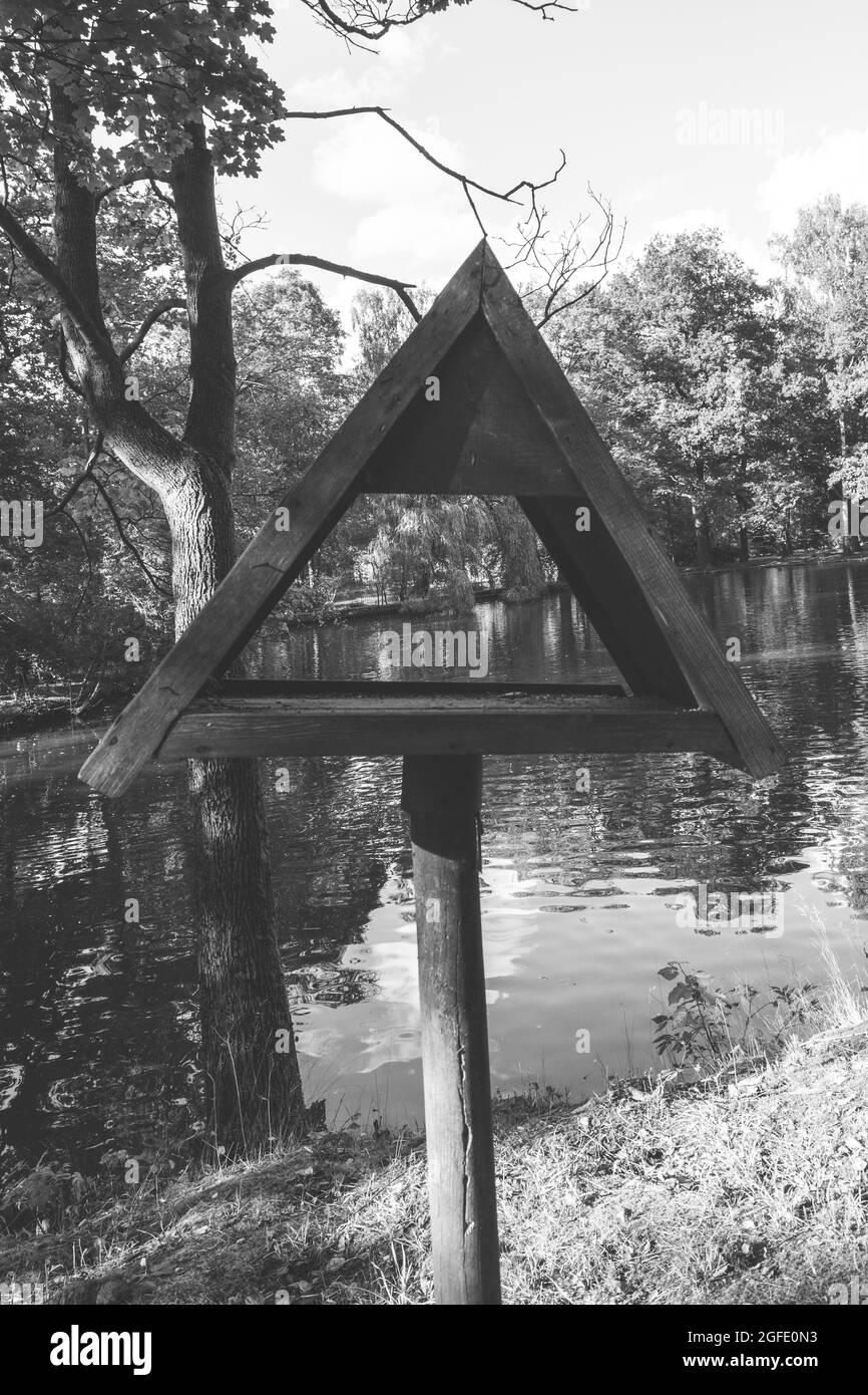 Vertical grayscale of a triangle figure on the top of a post standing ...