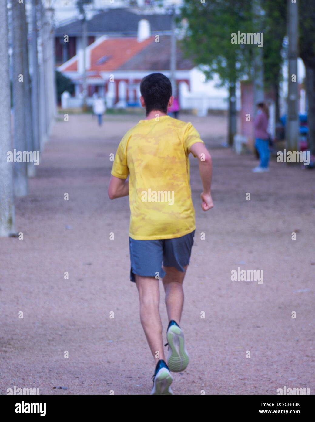 Vertical shot of a man running in a street Stock Photo - Alamy