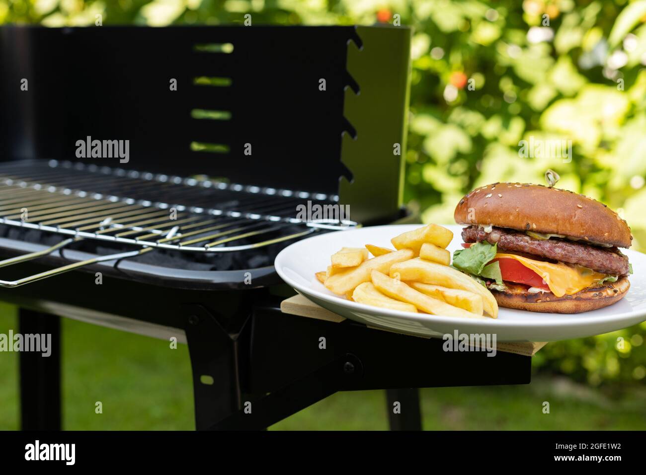 Homemade tasty cheeseburger being cooked on a on backyard barbecue ...