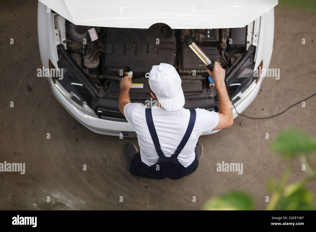 Top view rear view shot of a car mechanic repairing engine of an auto ...