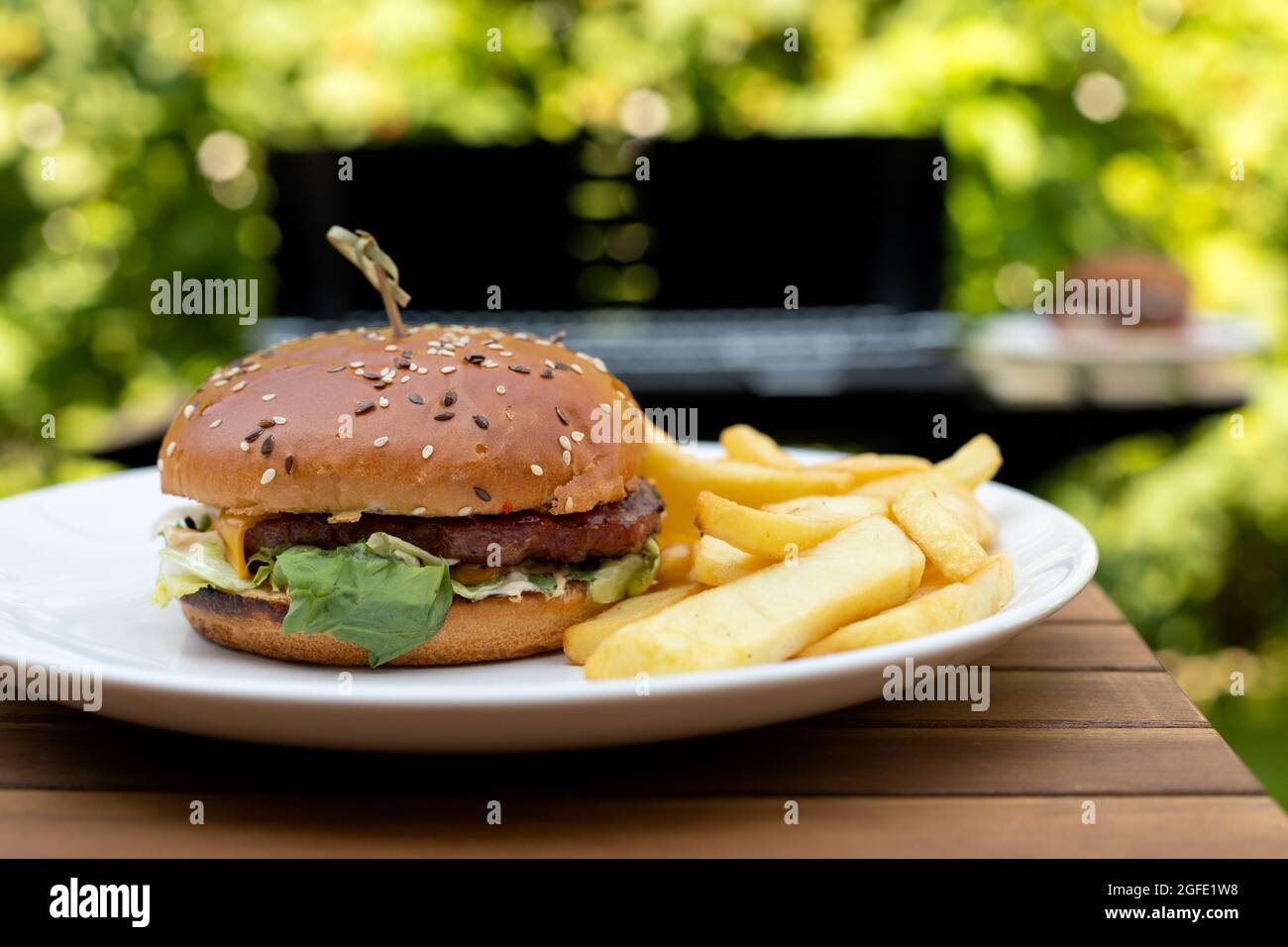 Homemade tasty cheeseburger being cooked on a on backyard barbecue ...