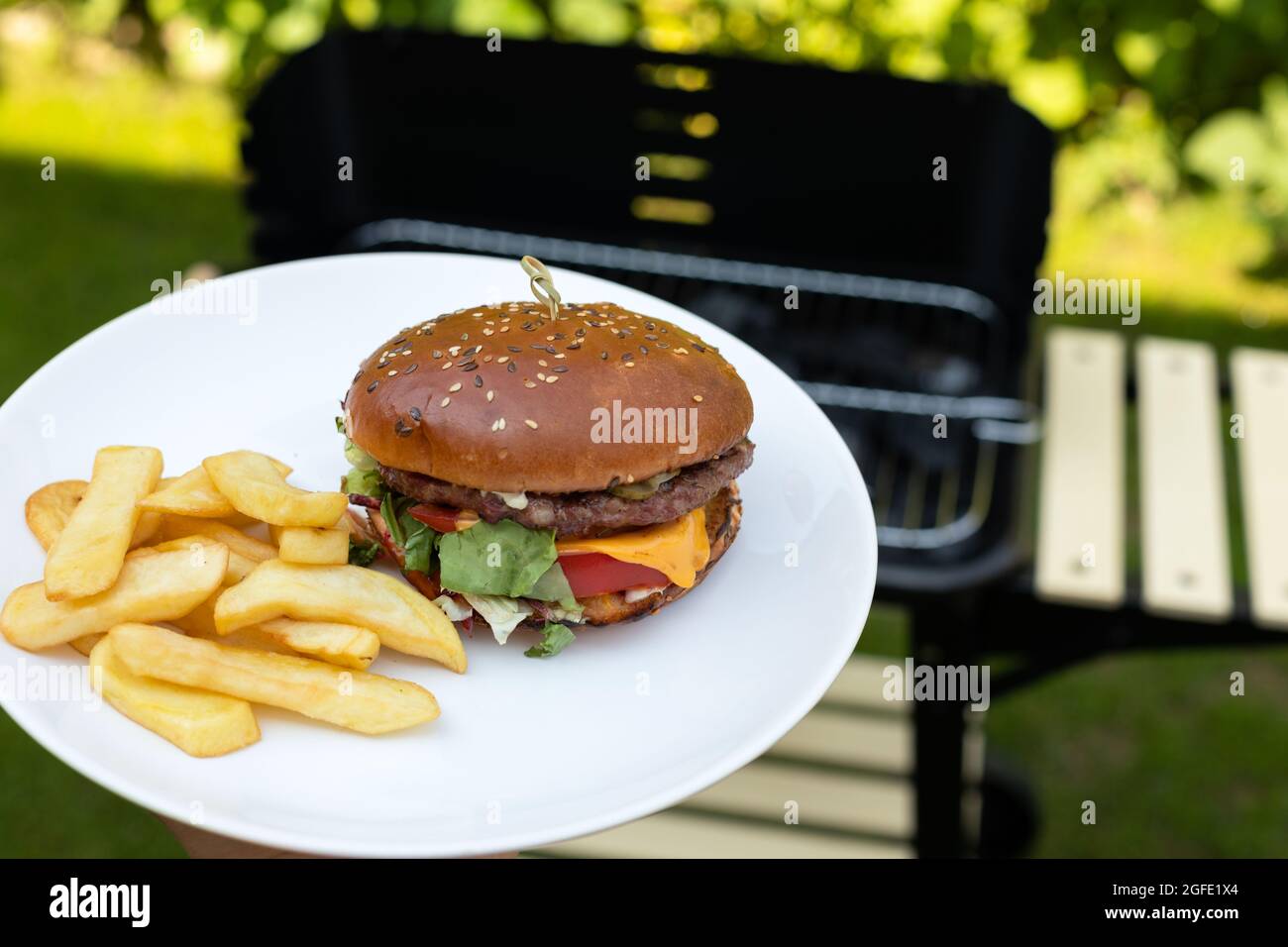 Homemade tasty cheeseburger being cooked on a on backyard barbecue ...