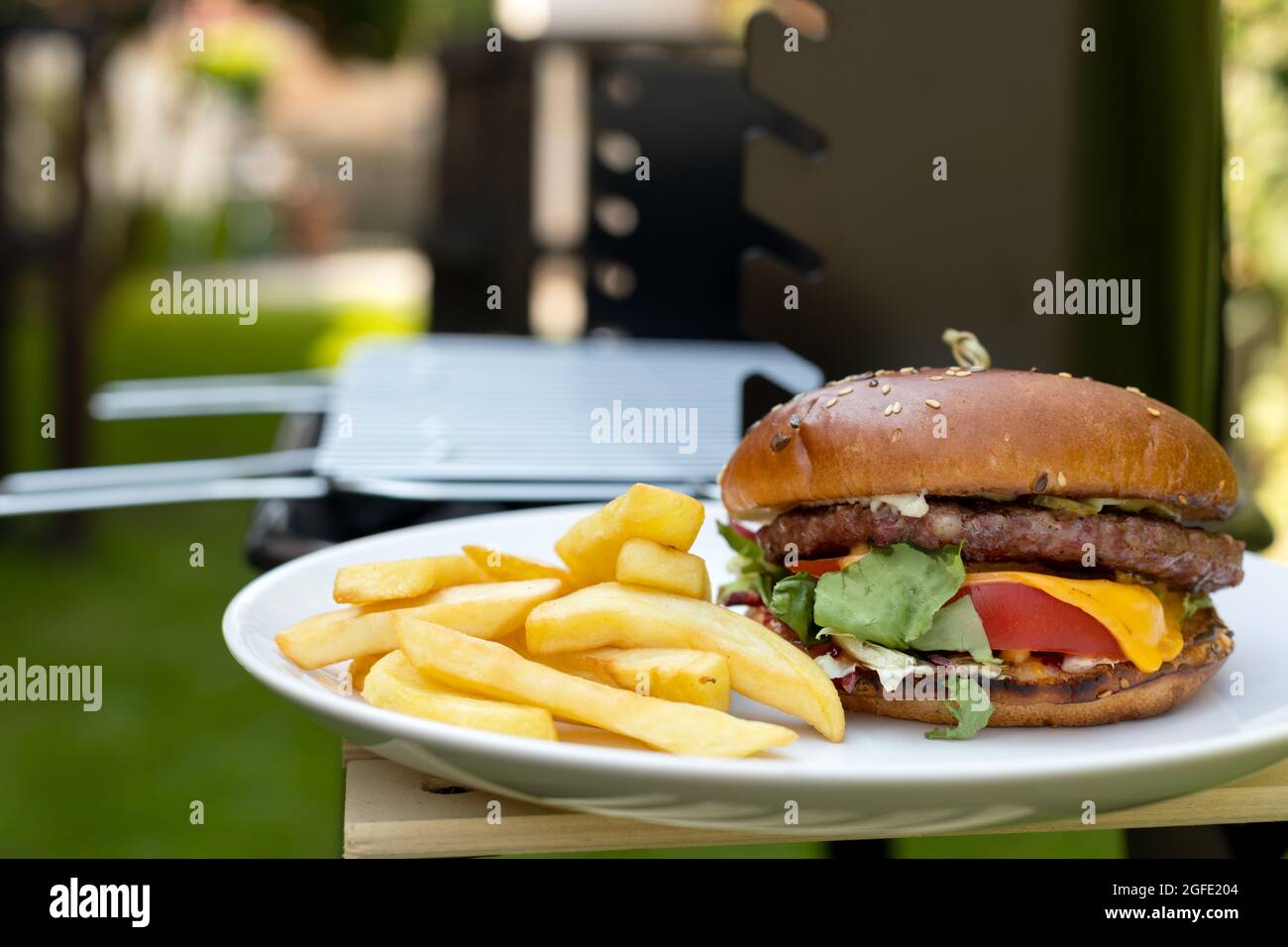 Homemade tasty cheeseburger being cooked on a on backyard barbecue ...