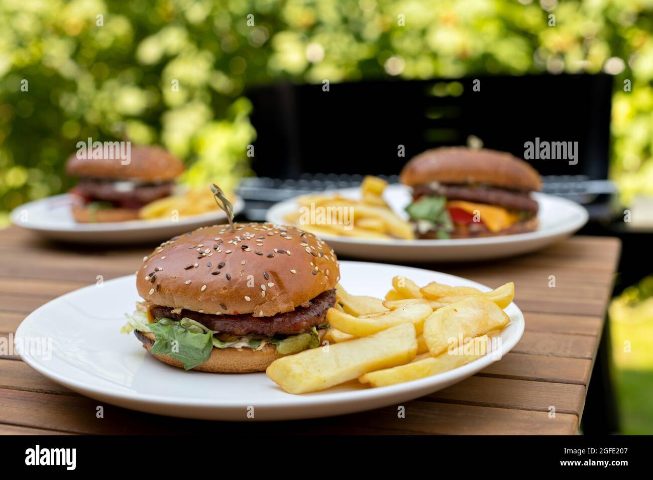 Homemade tasty cheeseburger being cooked on a on backyard barbecue ...