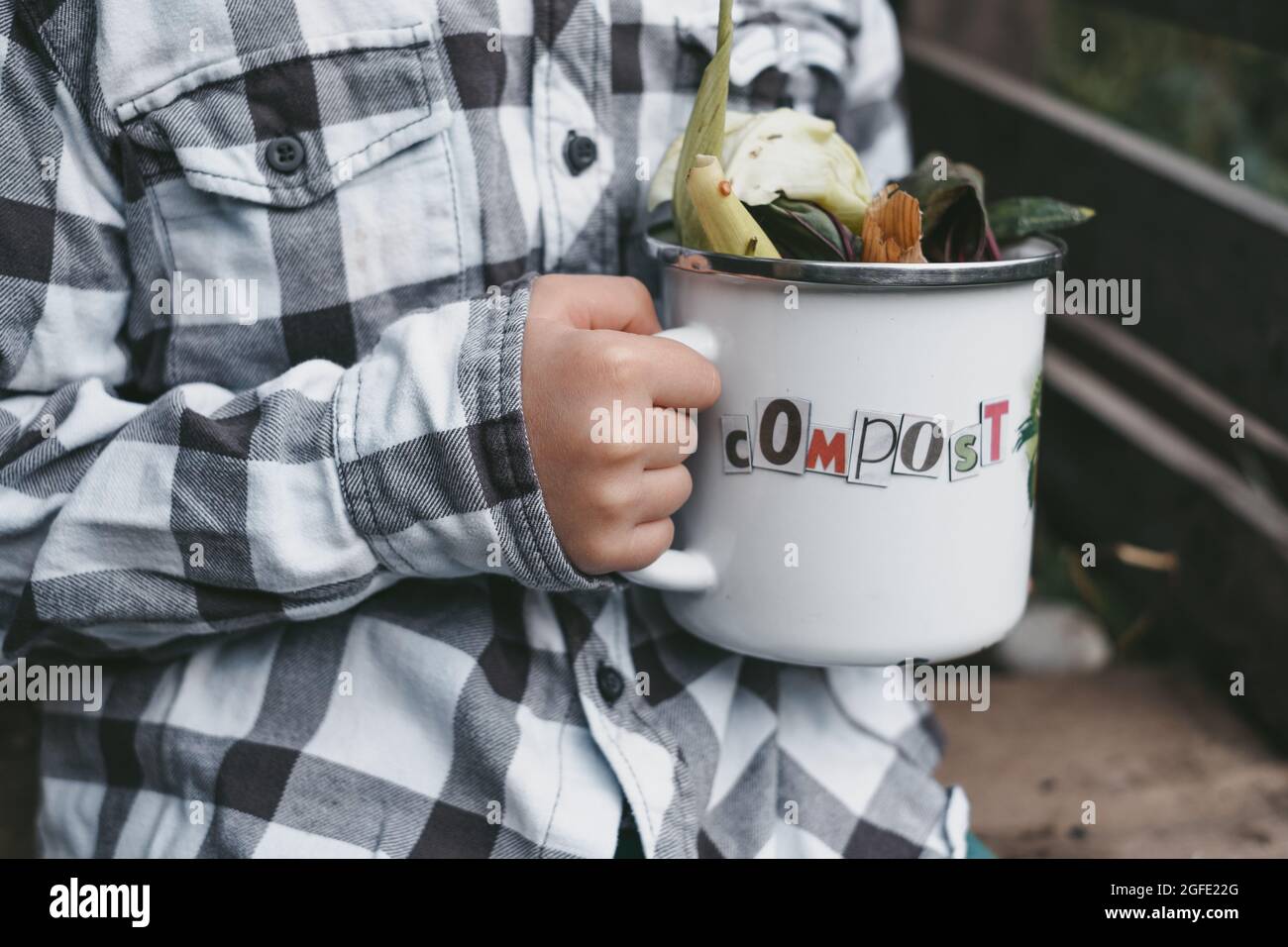 Children's hand holding compost bin with food scraps Stock Photo - Alamy