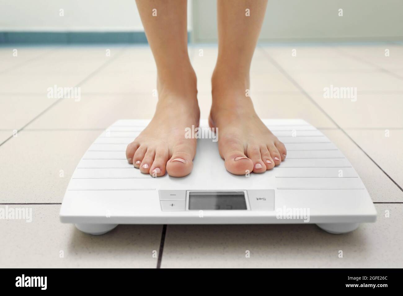Female legs standing on floor scales Stock Photo - Alamy