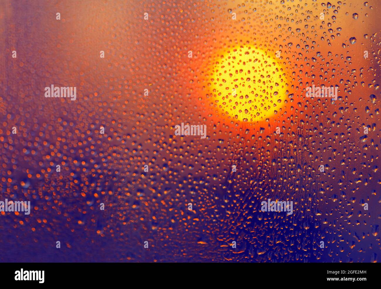 Sun and water drops on the glass . Sunset in the rain Stock Photo - Alamy