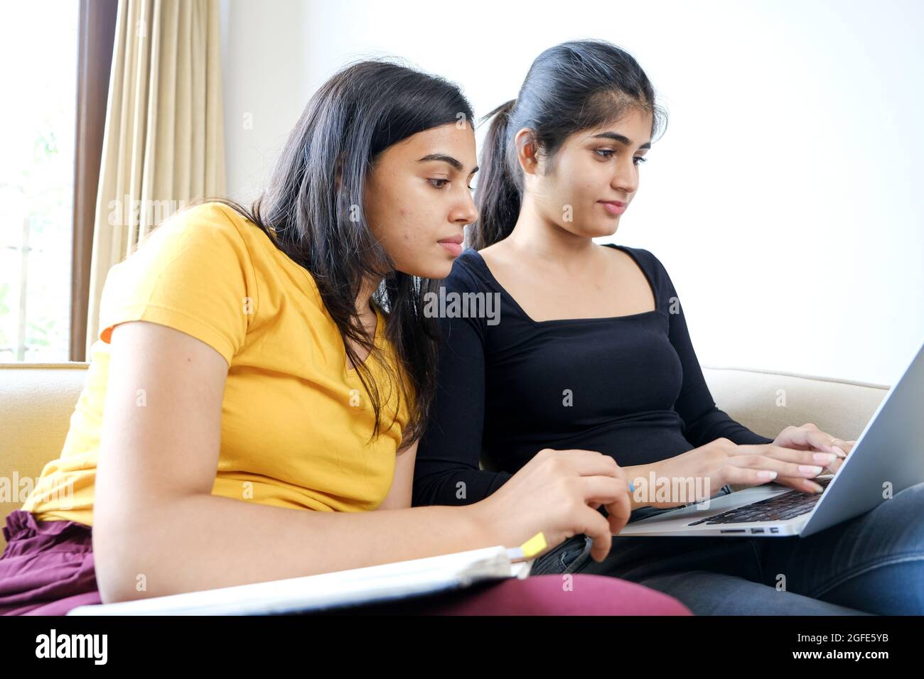 Closeup of two girls studying with a laptop Stock Photo - Alamy