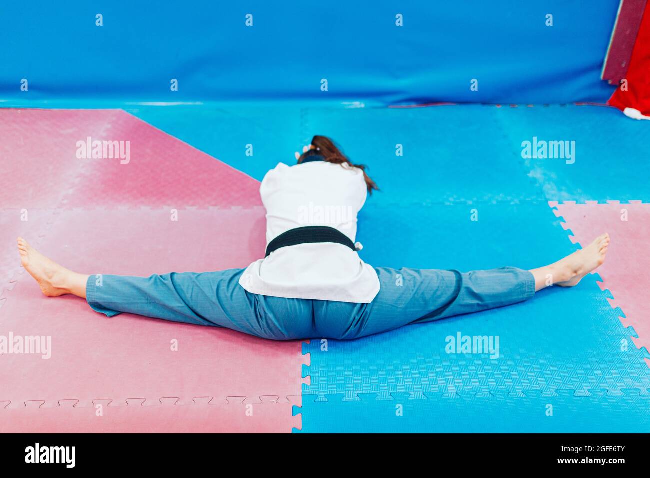 Young woman stretching in a dojo wearing taekwondo dobok Stock Photo ...