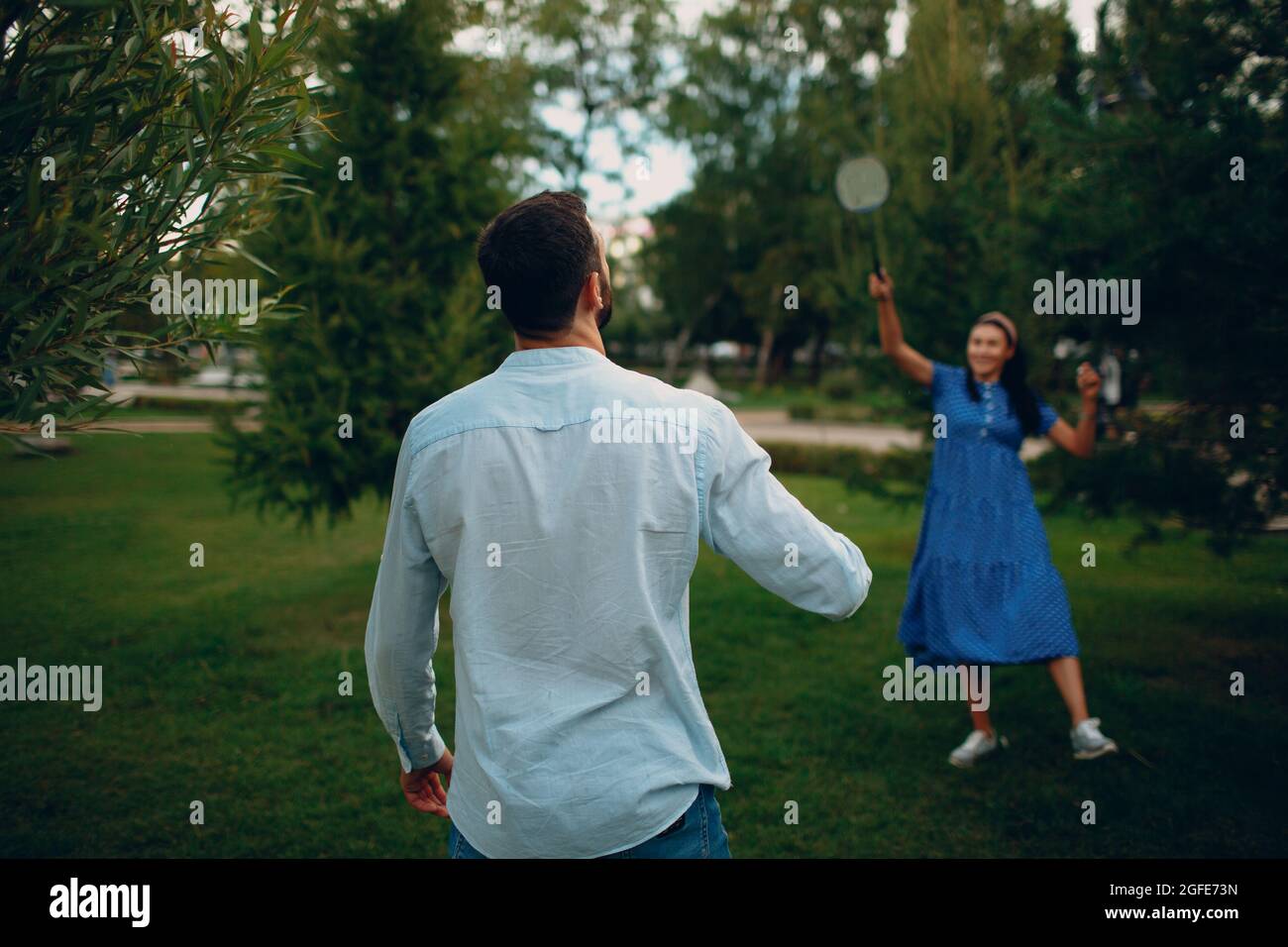 Young adult couple playing badminton in the park Stock Photo - Alamy