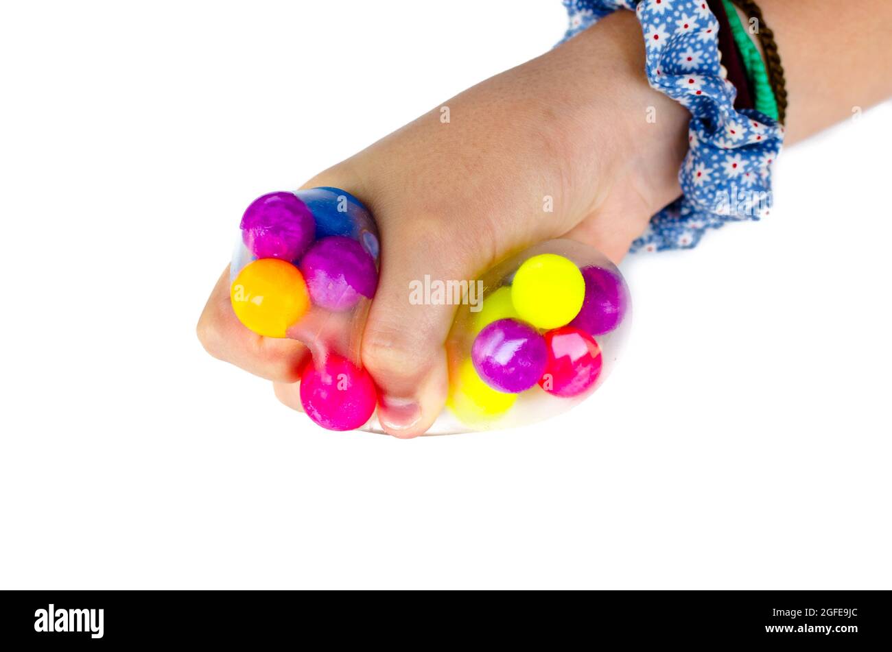 Closeup shot of a female hand squishing a colorful stress ball isolated ...