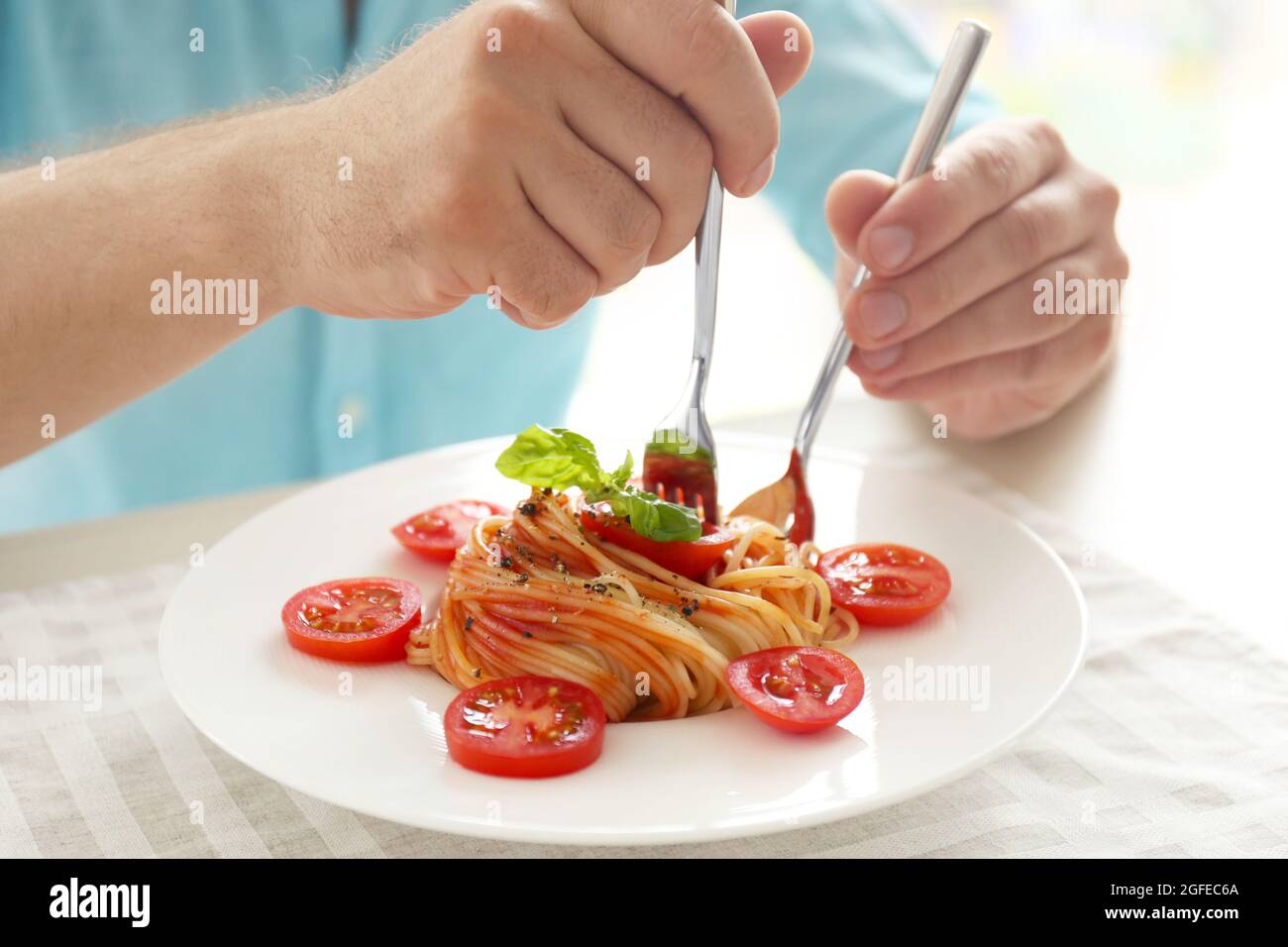 Man eating delicious pasta in restaurant Stock Photo - Alamy