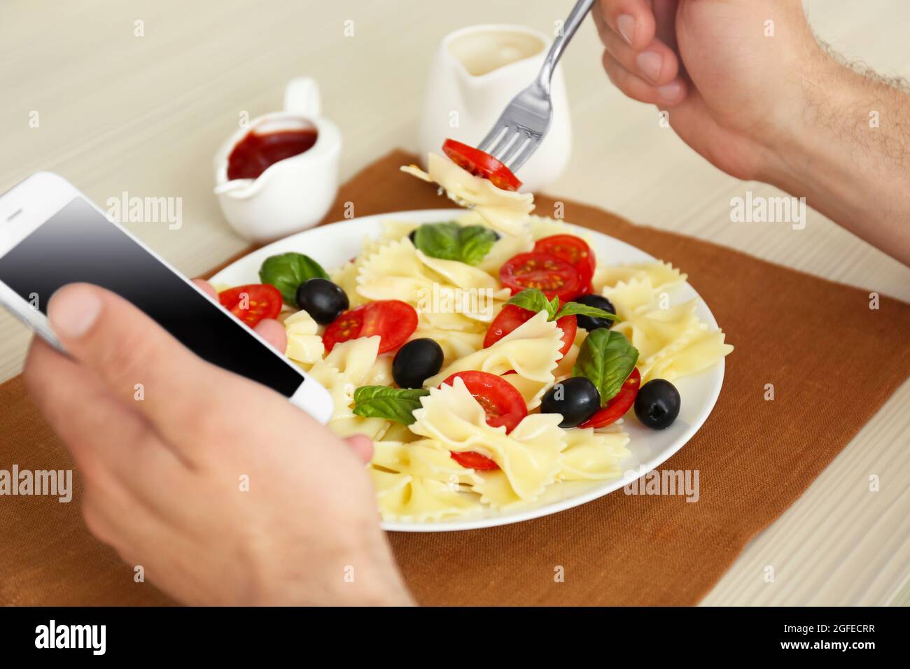 Man eating delicious pasta in restaurant Stock Photo - Alamy