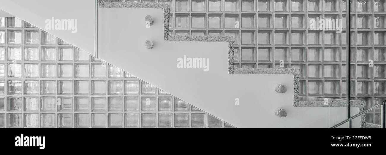 Transparent walls and staircase in modern building against wall with ...