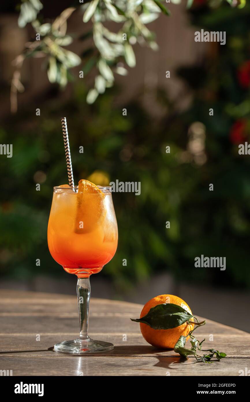 Aperol spritz cocktail with orange and paper straw on wood table Stock ...