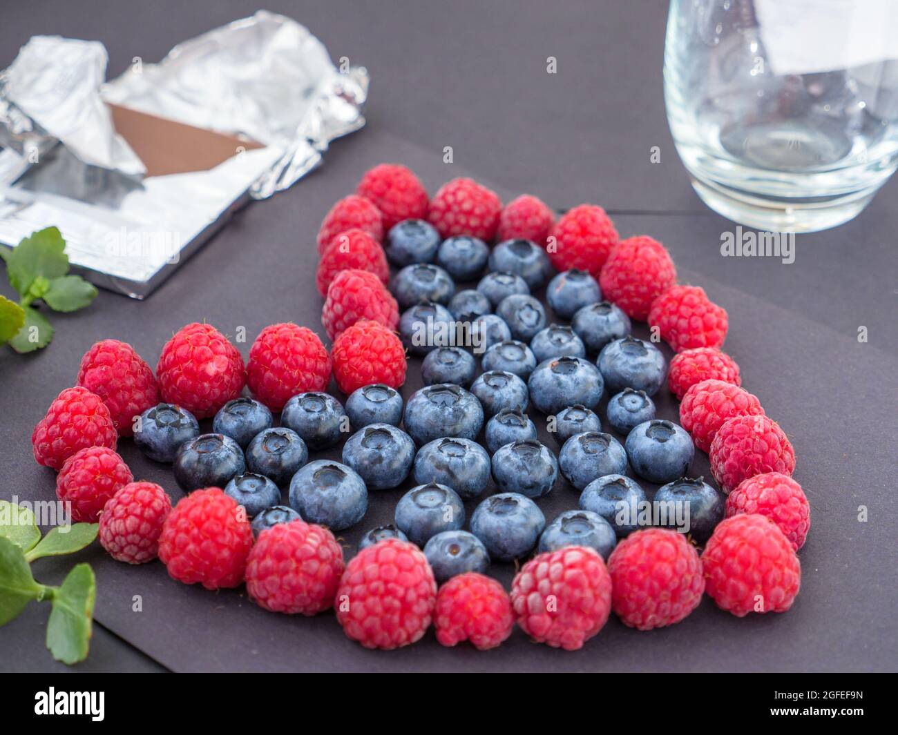 Heart shape love sign made of fresh raspberries and blueberries on ...