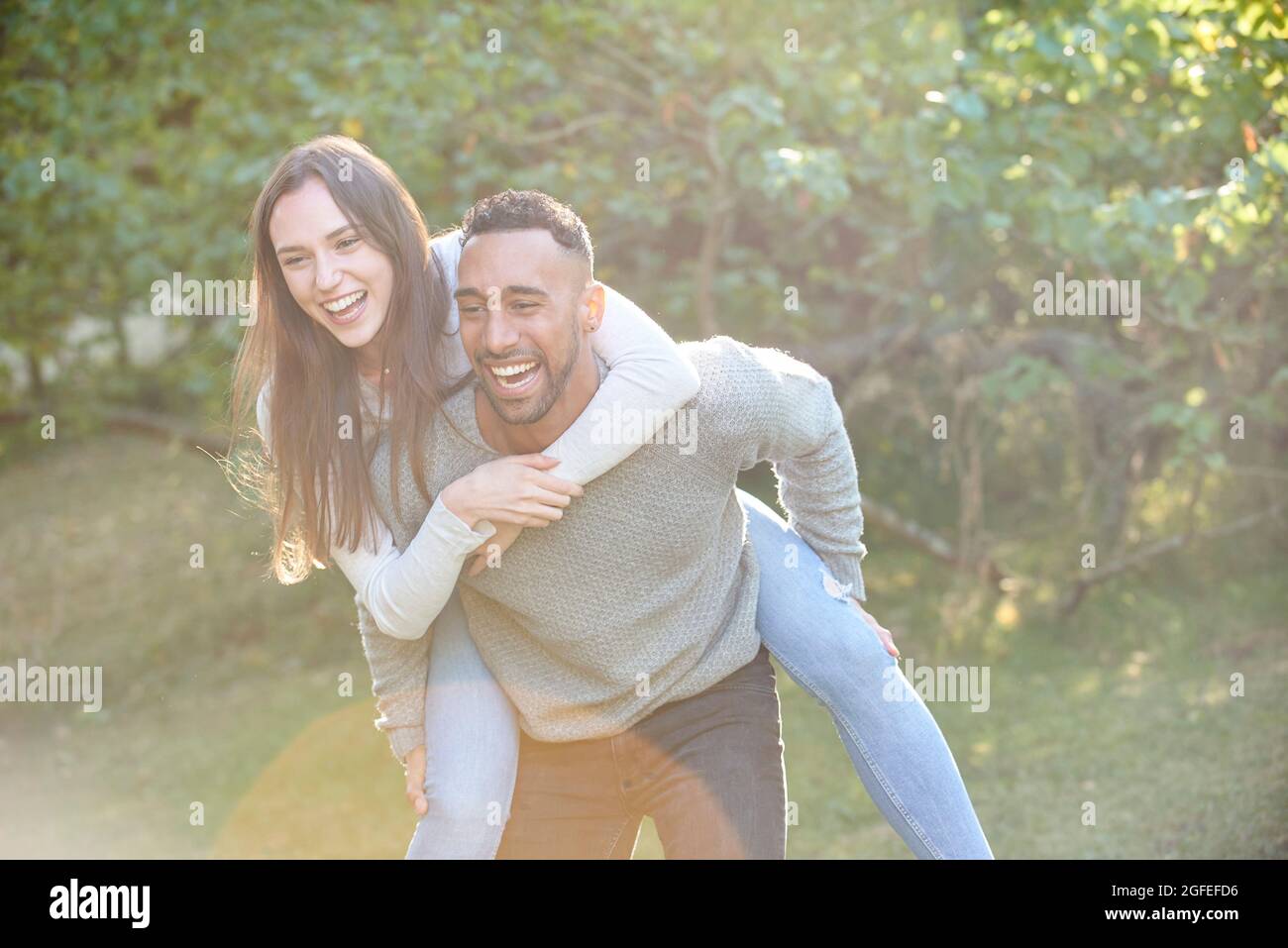 Smiling young man giving piggyback ride to his partner Stock Photo - Alamy