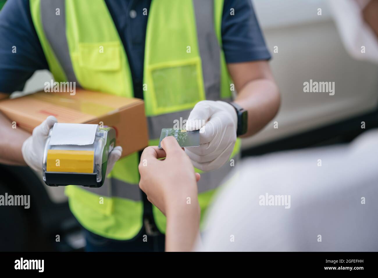 Close up hand of delivery man accept credit card using a credit card ...