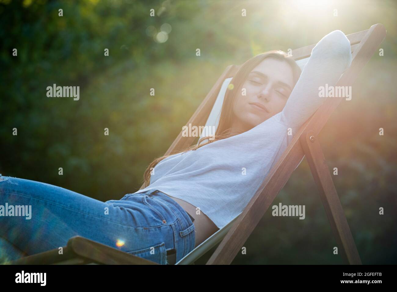 Young woman sleeping on chair in park Stock Photo - Alamy