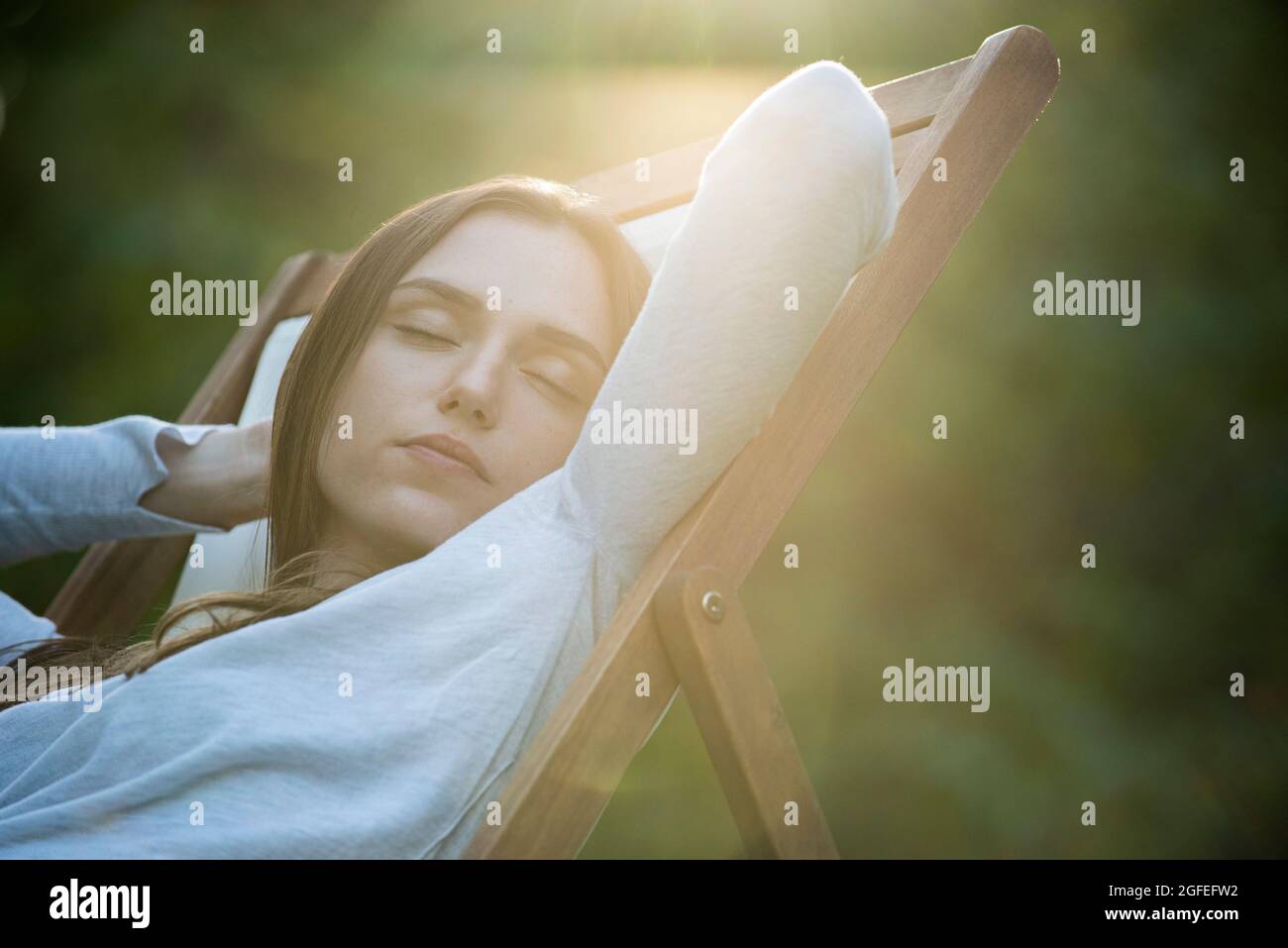 Young woman sleeping on chair in park Stock Photo - Alamy