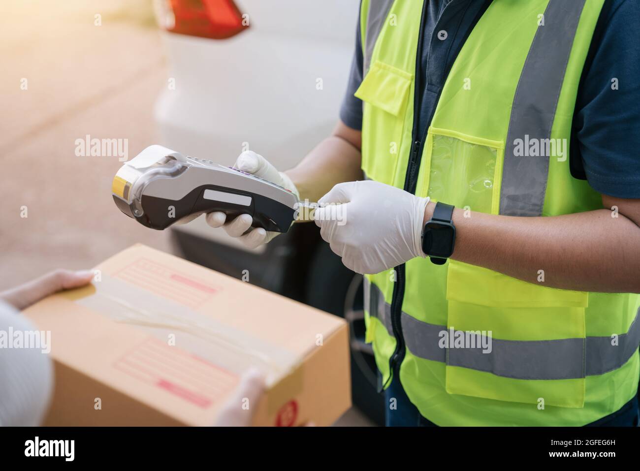 Close up hand of delivery man using a credit card reader while ...