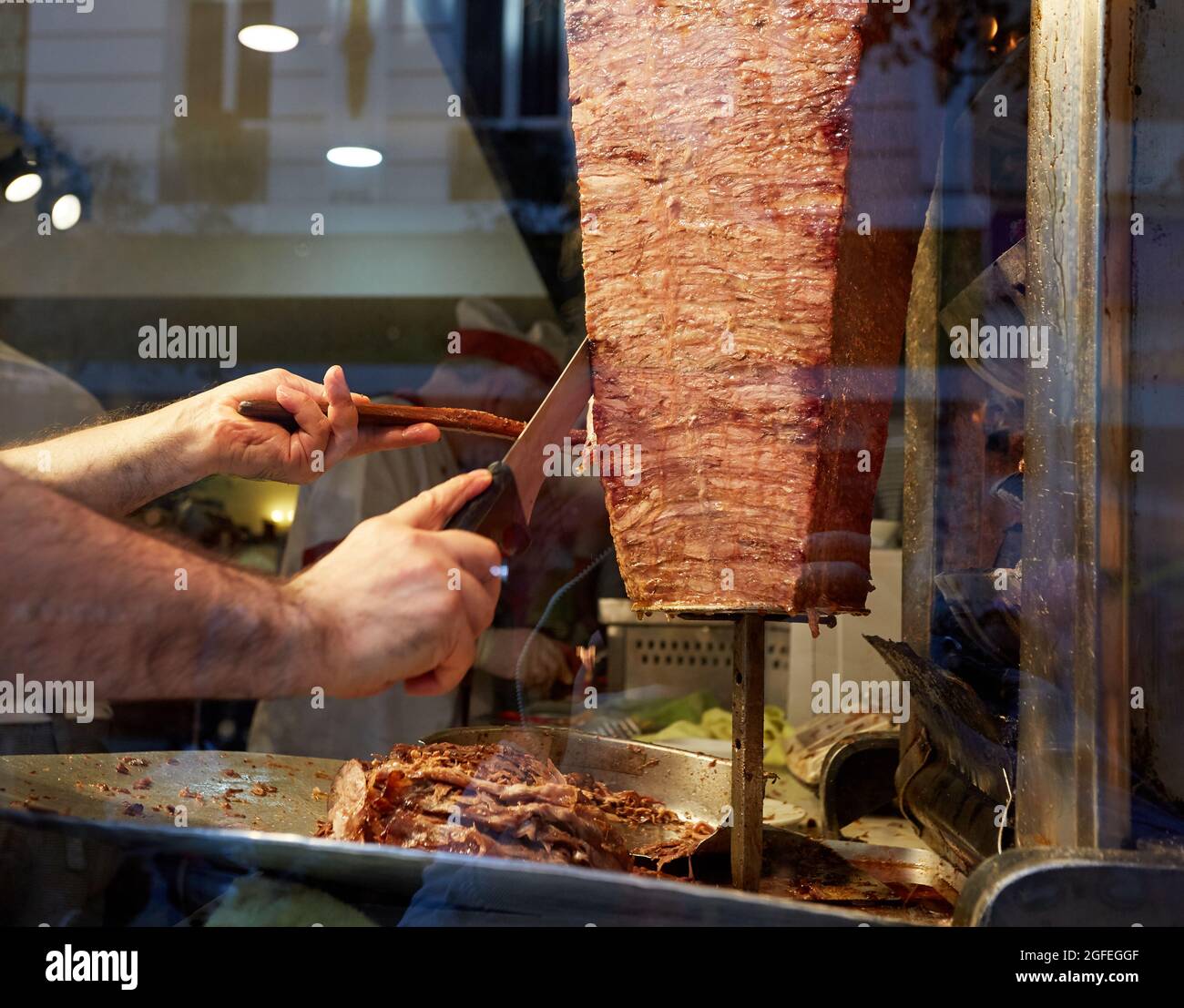 An arm moving to cut the kebab meat Stock Photo - Alamy