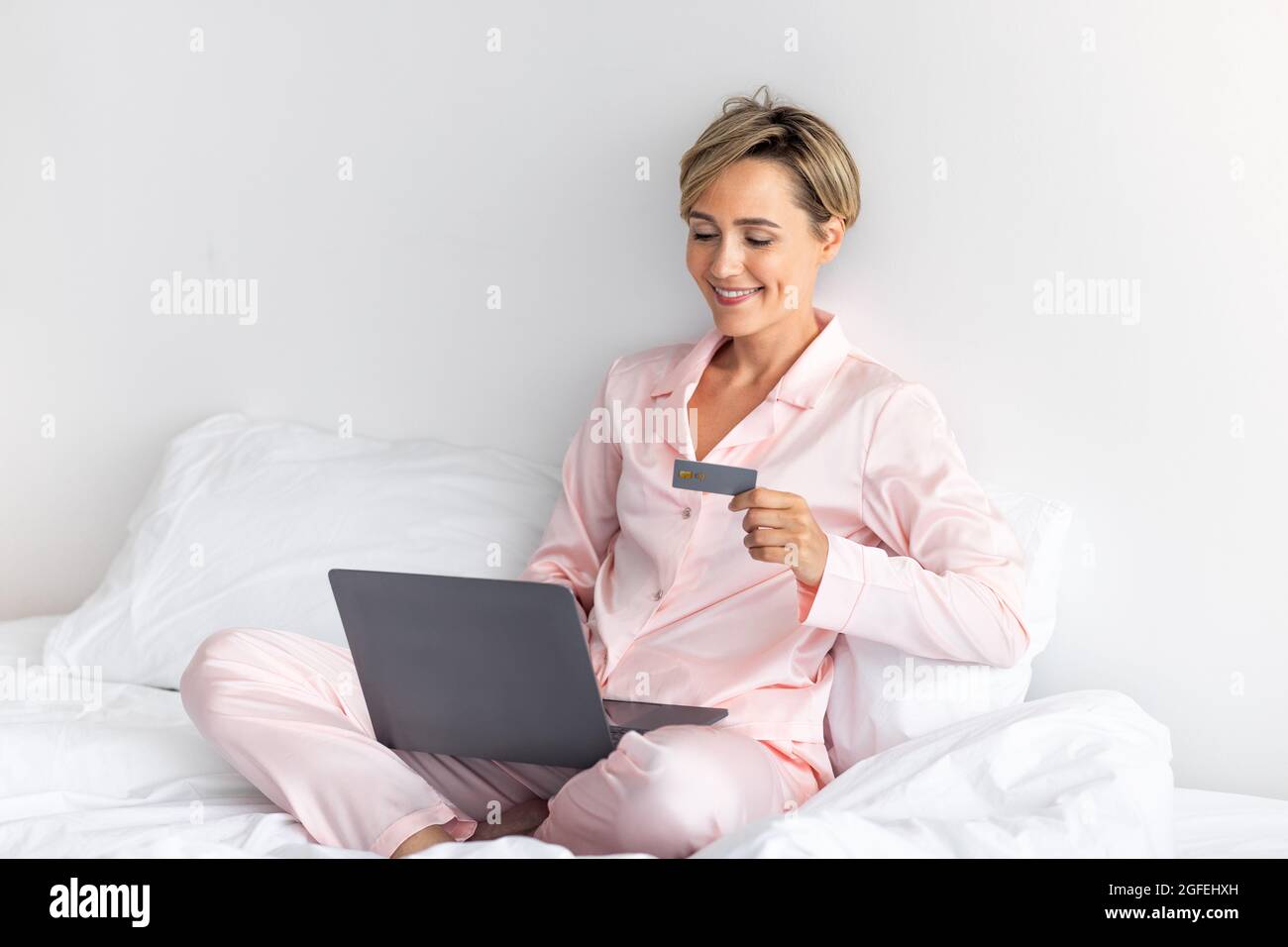 Happy woman holding debit credit card, using pc Stock Photo - Alamy