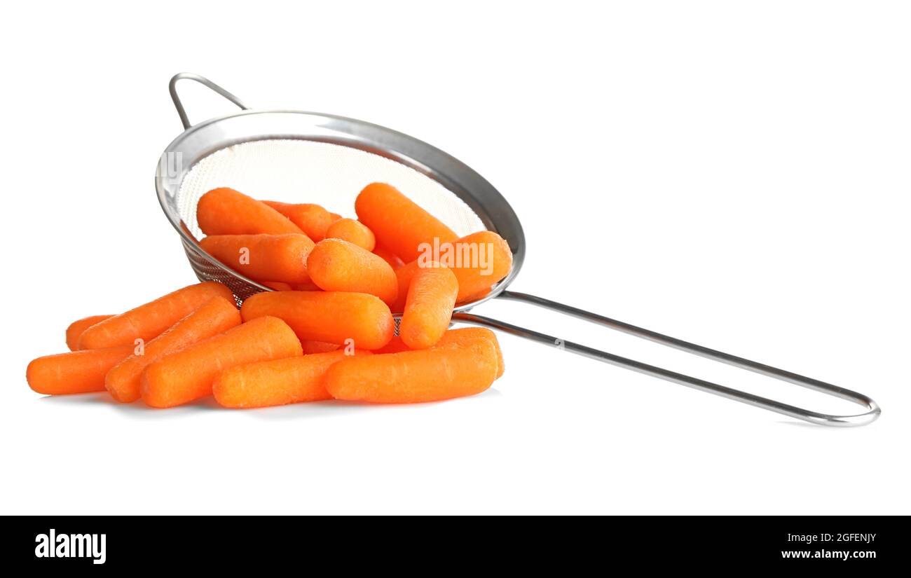 Small baby carrots in sieve on white background Stock Photo - Alamy