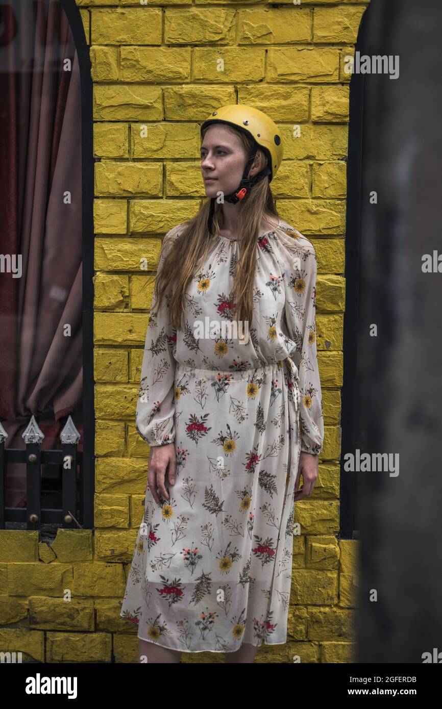 Pretty caucasian young woman in casual dress and yellow motorcycle ...