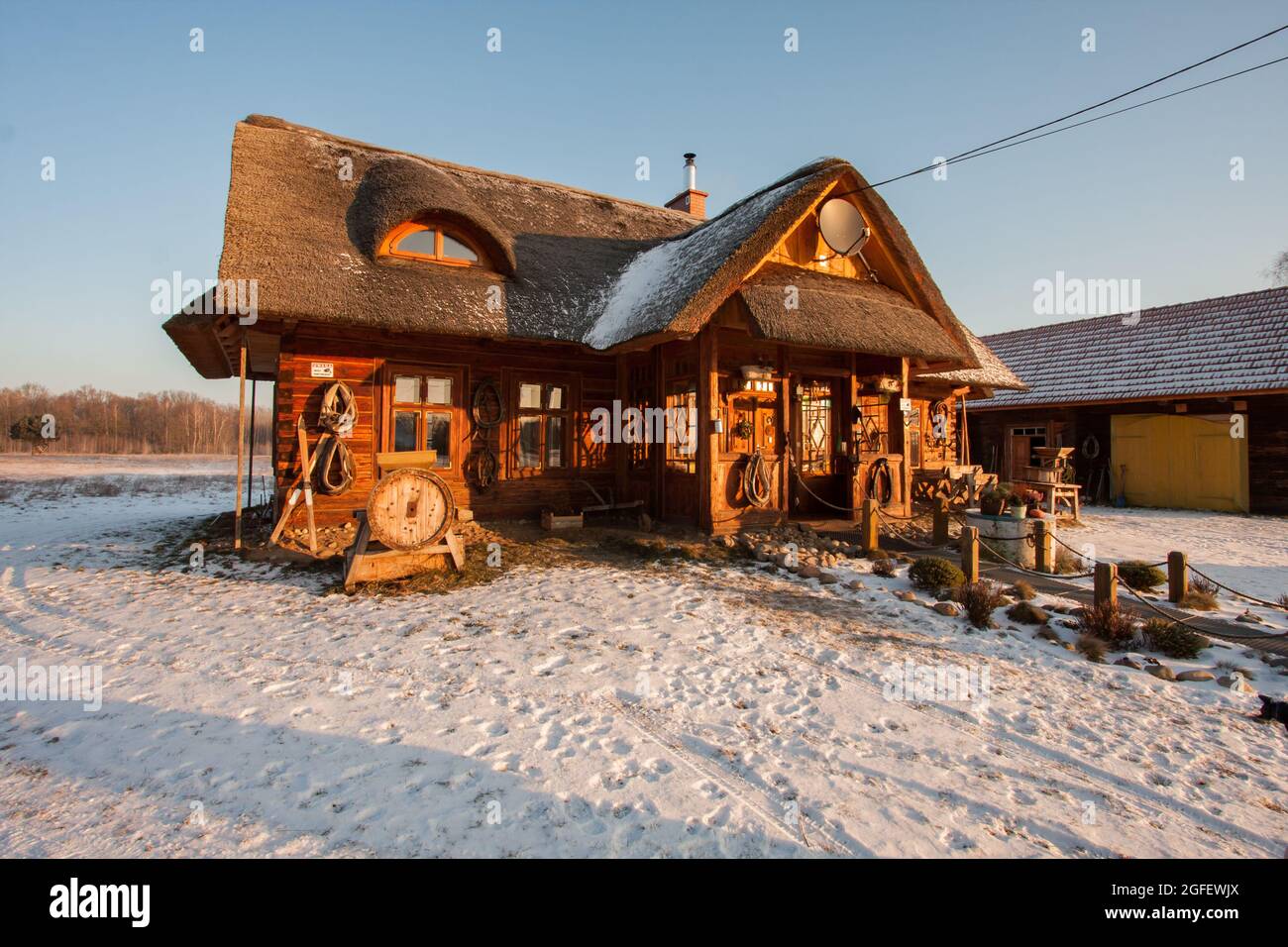 Poland January - 2017: Beautiful wooden thatched log house in the rays ...