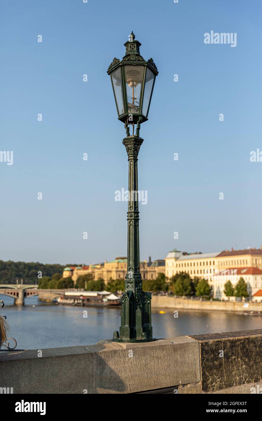 Single street lamp on a bridge with flowing water at sunset in Europe ...