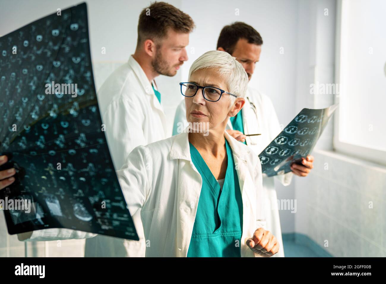 Radiologist doctor consulting with colleagues an x-ray scan in hospital ...