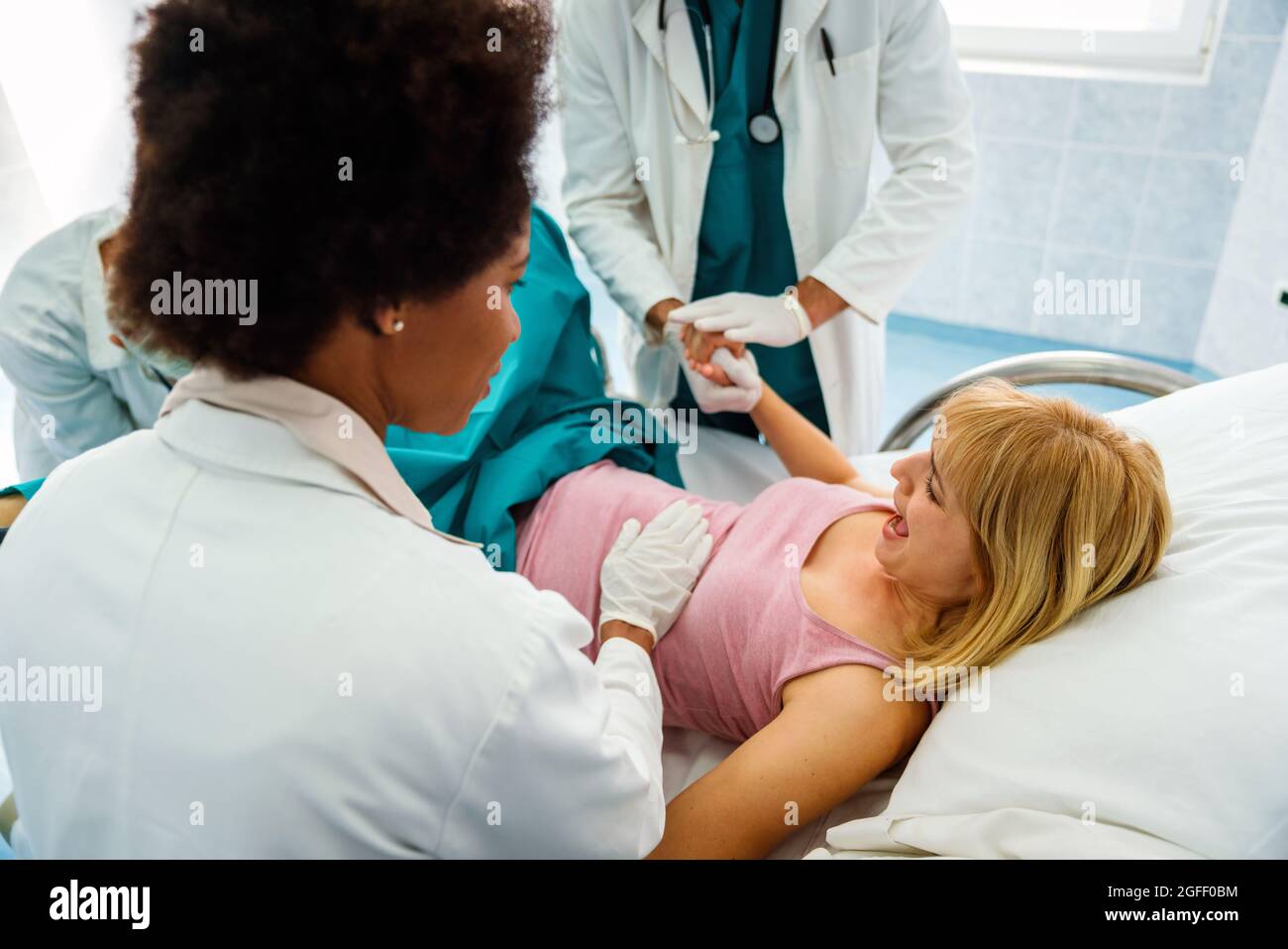 Pregnant woman pushes to give birth in hospital, obstetrician doctor ...