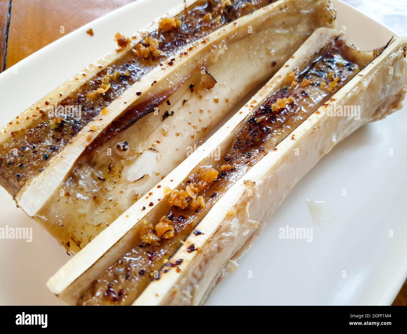 close up shot of delicious pair of bone marrow topped with fried garlic ...