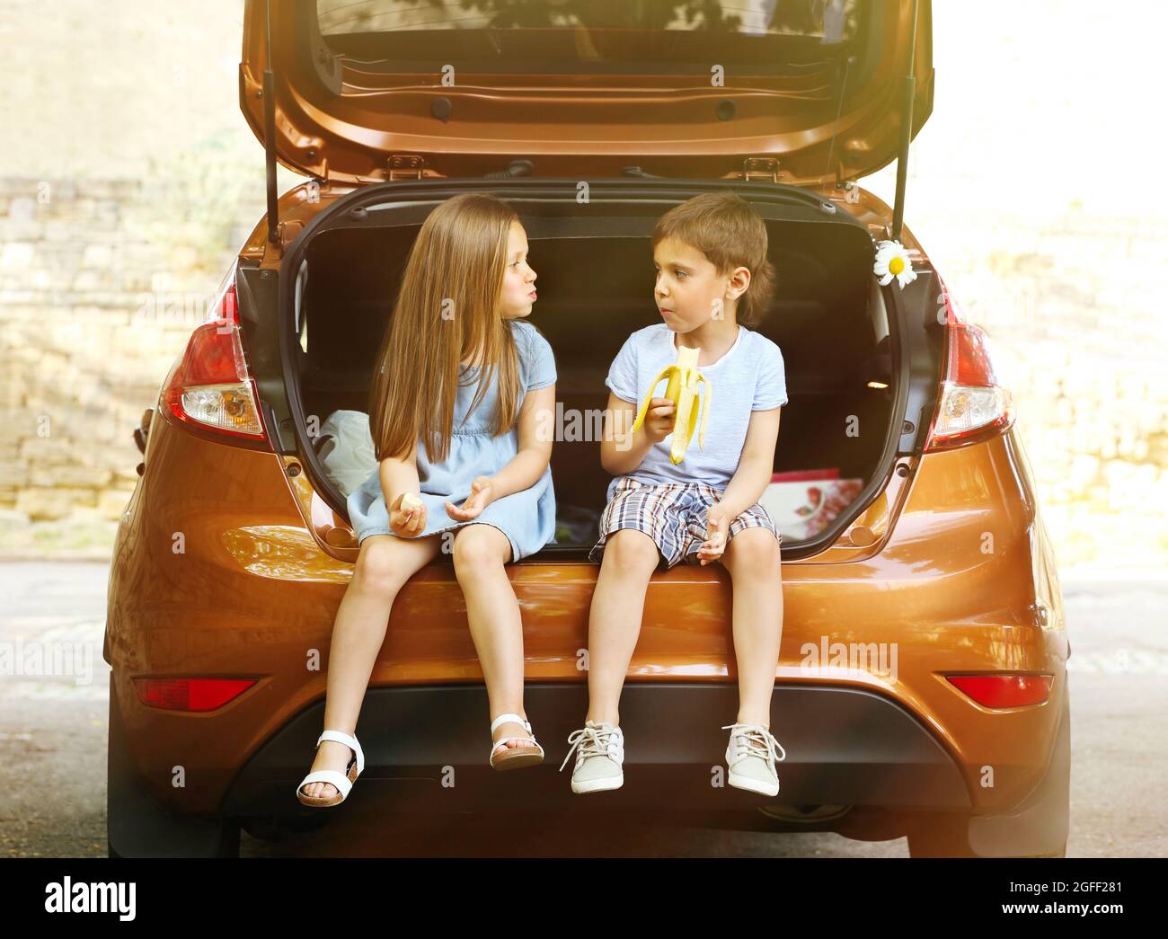 Two cute little kids in car trunk Stock Photo - Alamy