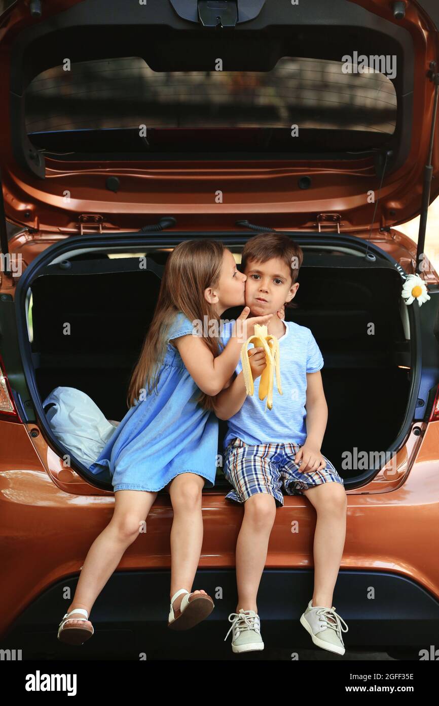 Two cute little kids in car trunk Stock Photo - Alamy