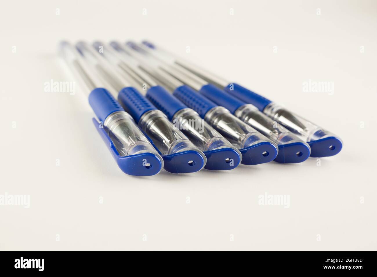 set of blue ballpoint pens lined up hardly on a white background Stock ...